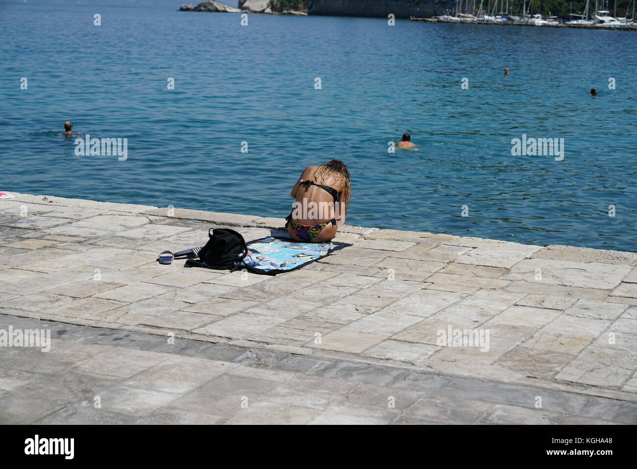 Corfu, Greece: People at the beach swimming and sunbathing Stock Photo ...