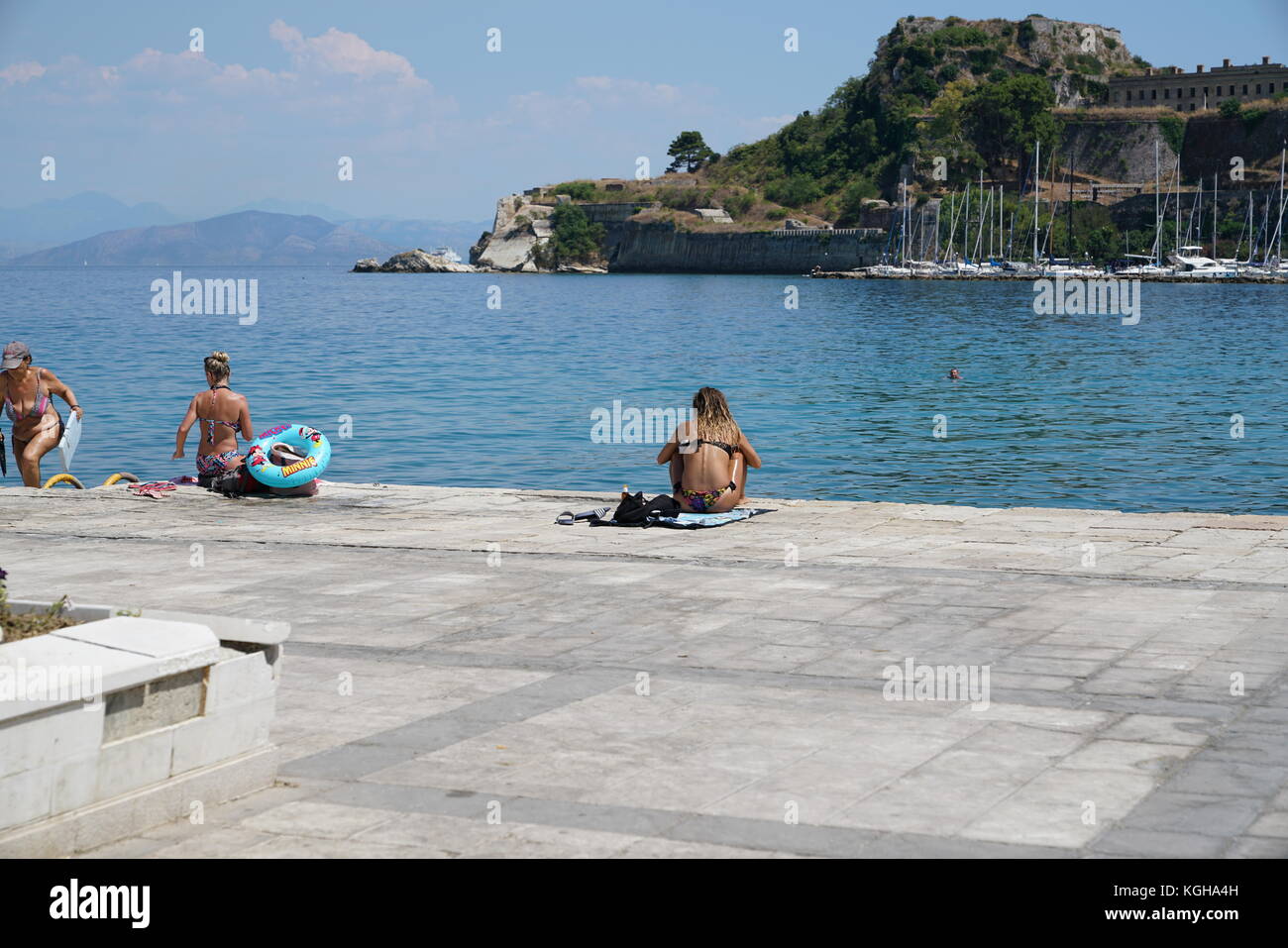 Corfu, Greece: People at the beach swimming and sunbathing Stock Photo ...