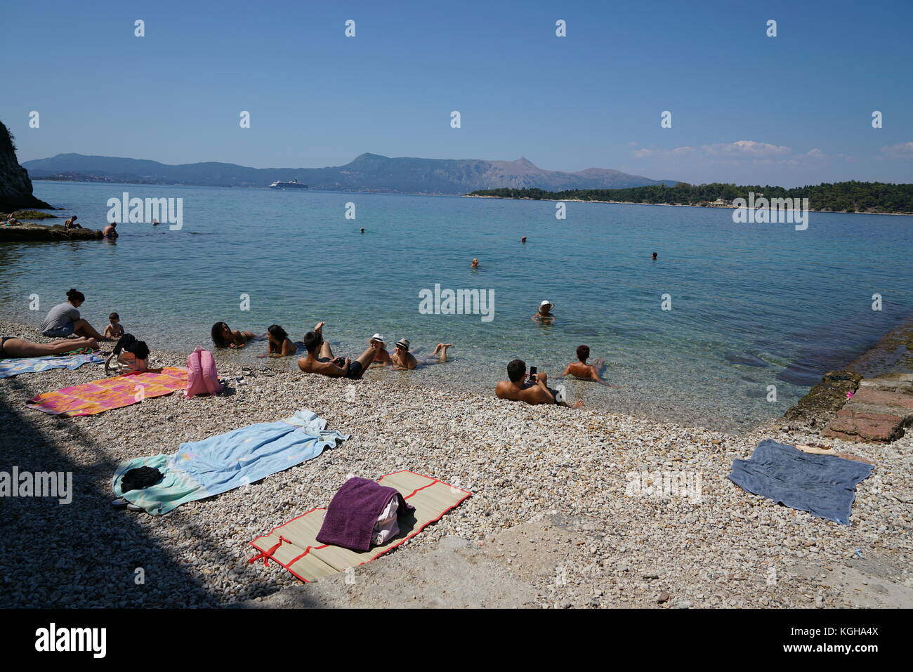 Corfu, Greece: People at the beach swimming and sunbathing Stock Photo ...