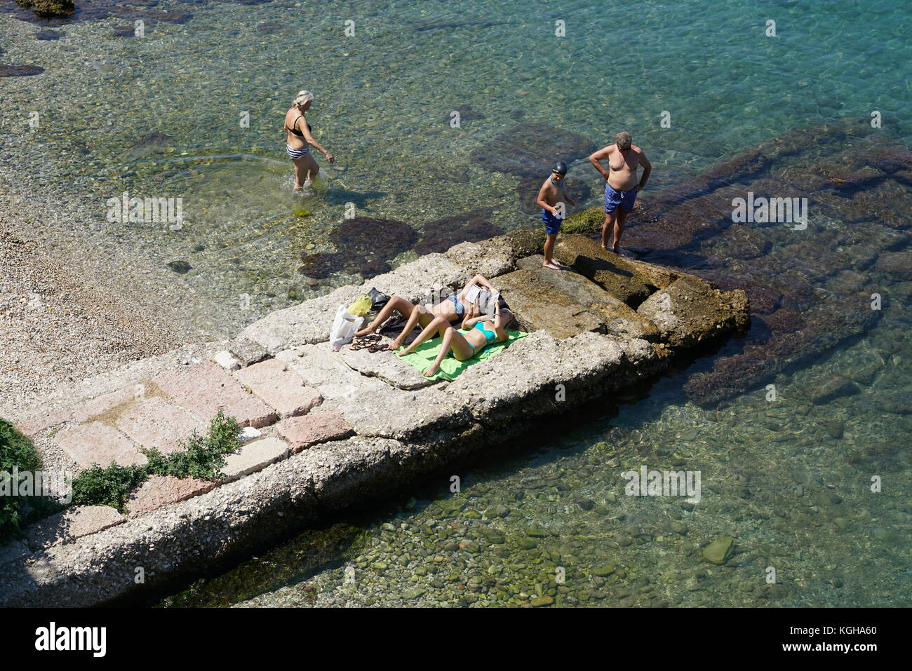 Corfu, Greece: People at the beach swimming and sunbathing Stock Photo ...