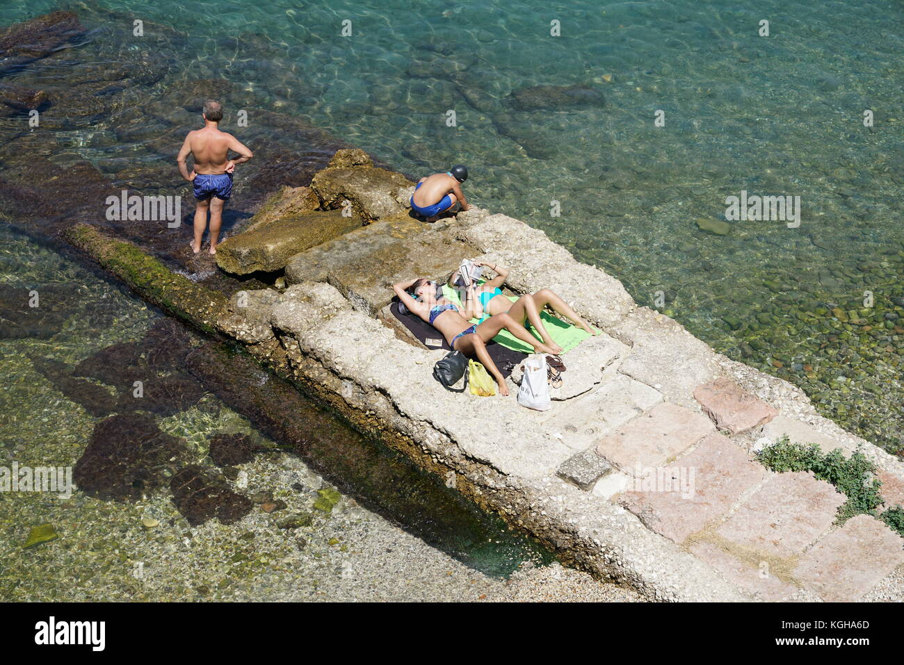Corfu, Greece: People at the beach swimming and sunbathing Stock Photo ...