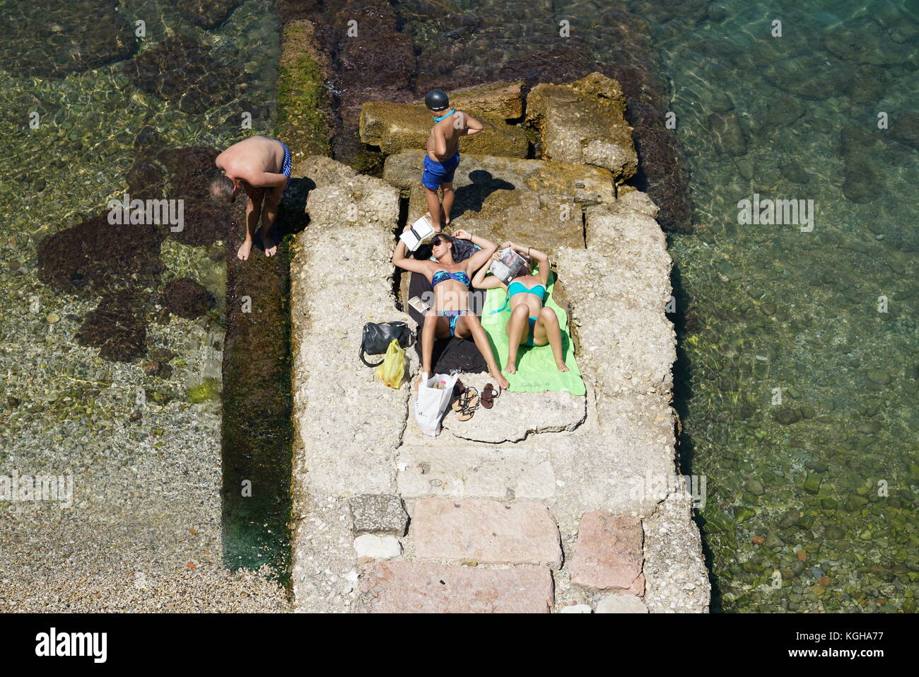 Corfu, Greece: People at the beach swimming and sunbathing Stock Photo ...