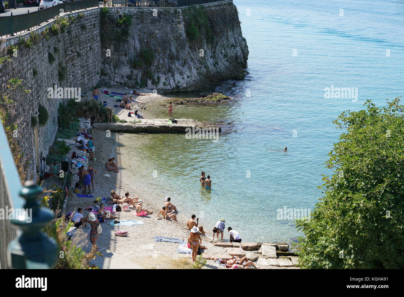 Corfu, Greece: People at the beach swimming and sunbathing Stock Photo ...