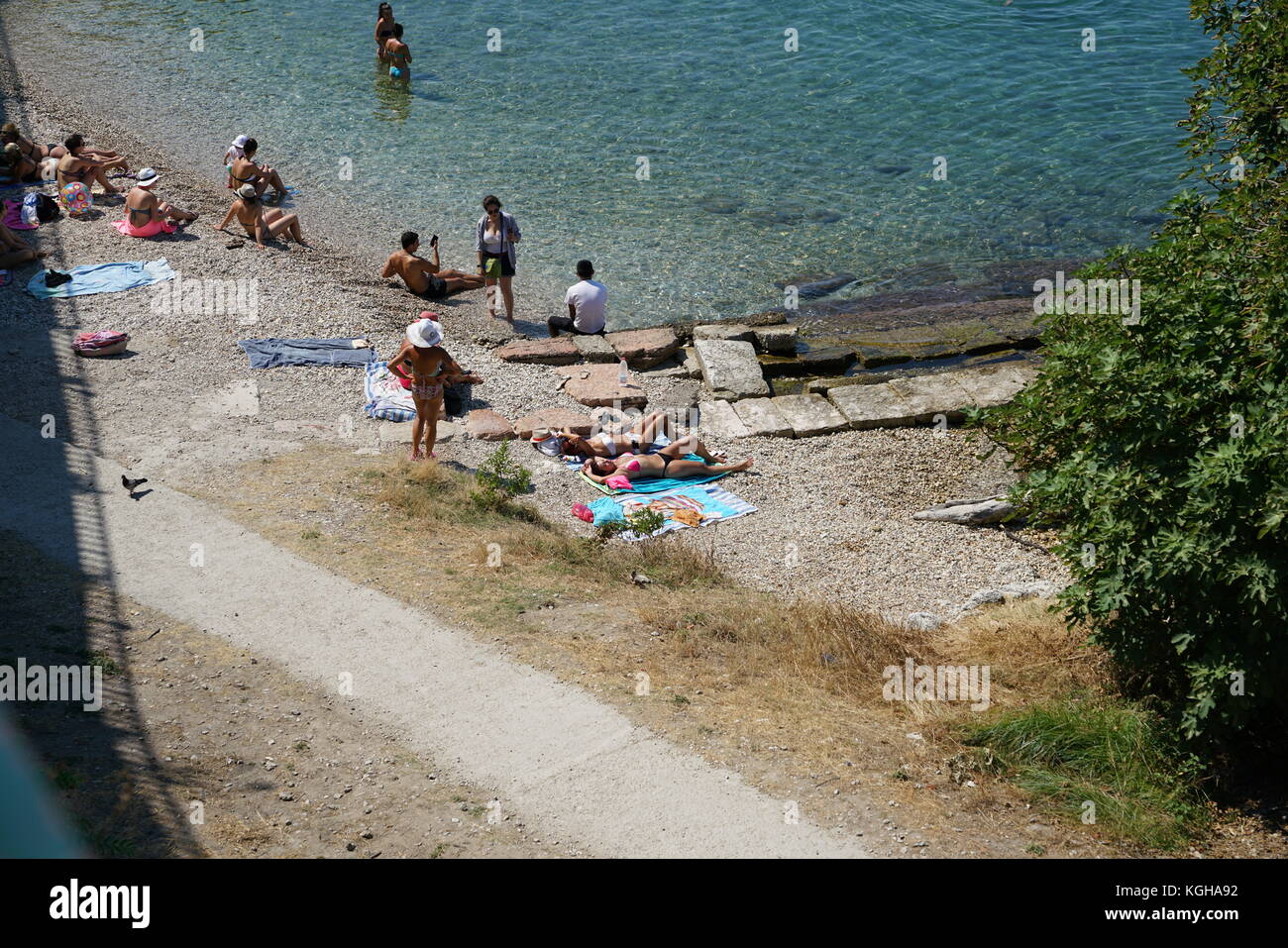 Corfu, Greece: People at the beach swimming and sunbathing Stock Photo ...
