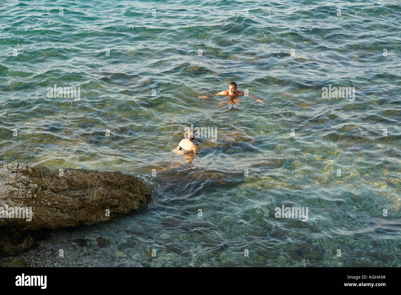 Corfu, Greece: People at the beach swimming and sunbathing Stock Photo ...