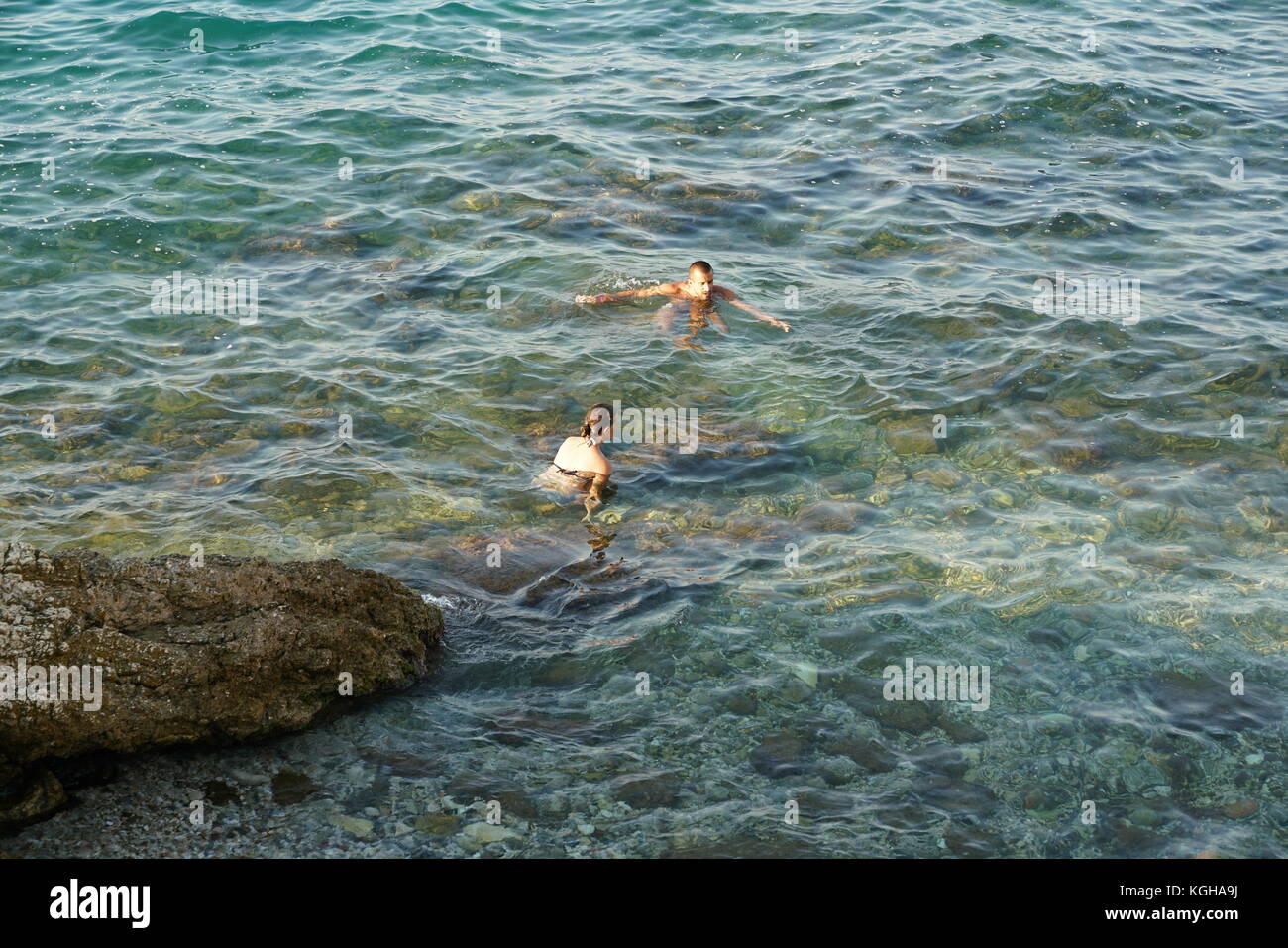 Corfu, Greece: People at the beach swimming and sunbathing Stock Photo ...