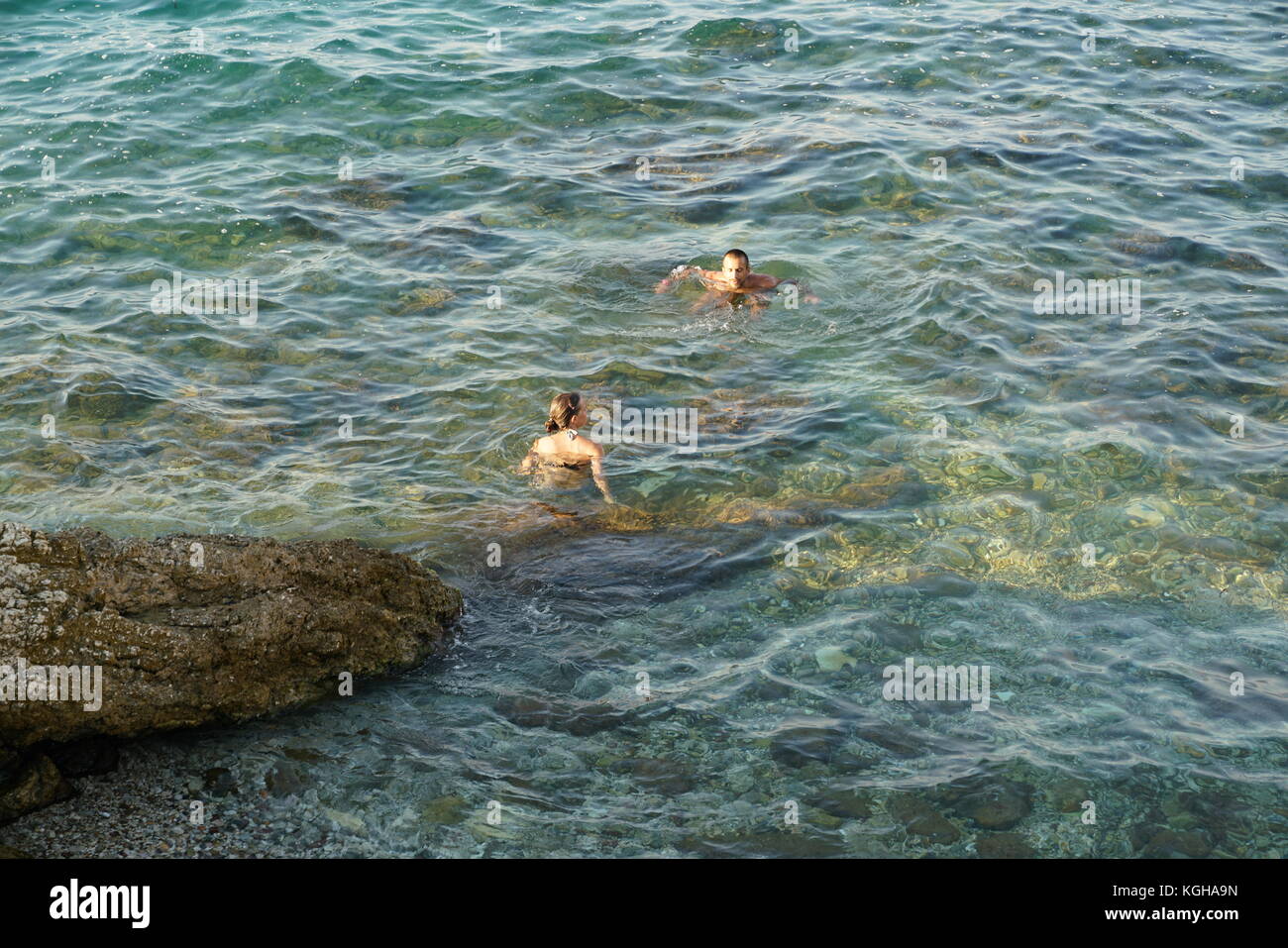 Corfu, Greece: People at the beach swimming and sunbathing Stock Photo ...