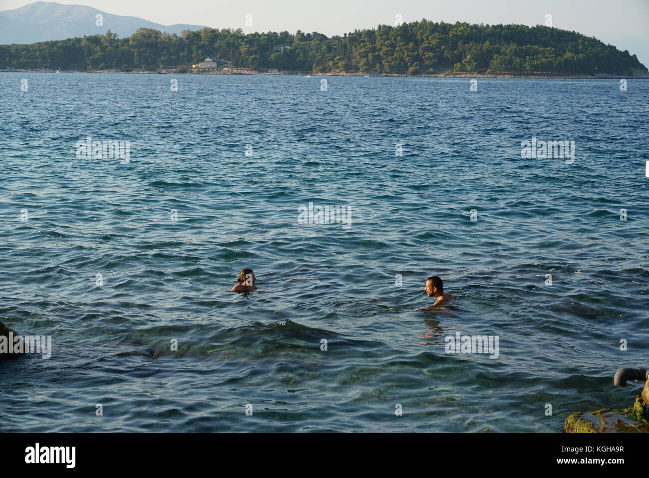 Corfu, Greece: People at the beach swimming and sunbathing Stock Photo ...