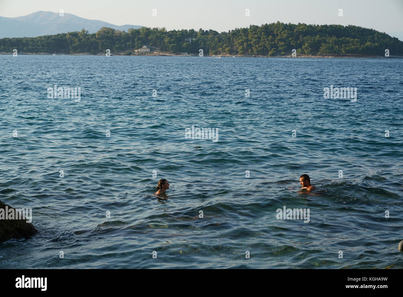 Corfu, Greece: People at the beach swimming and sunbathing Stock Photo ...