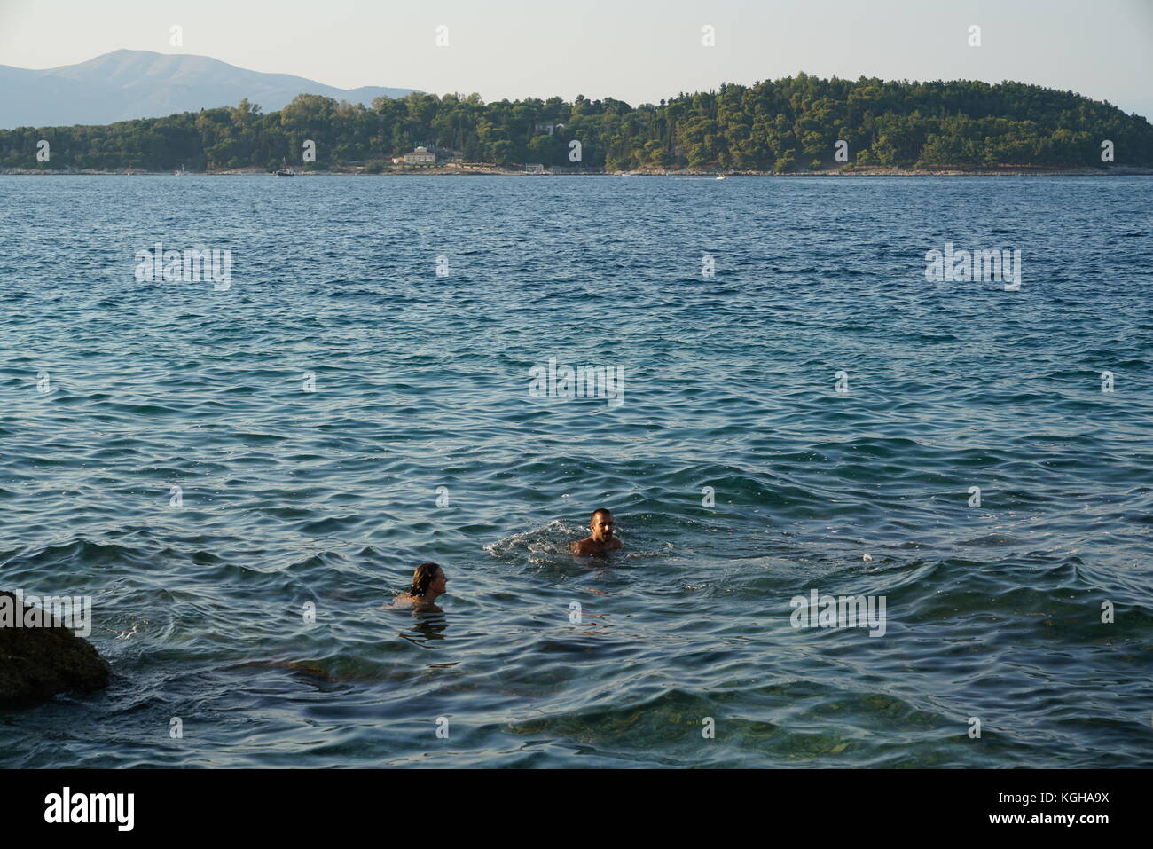 Corfu, Greece: People at the beach swimming and sunbathing Stock Photo ...
