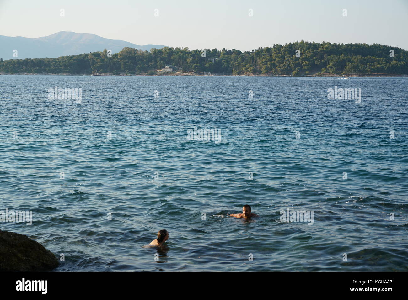 Corfu, Greece: People at the beach swimming and sunbathing Stock Photo ...