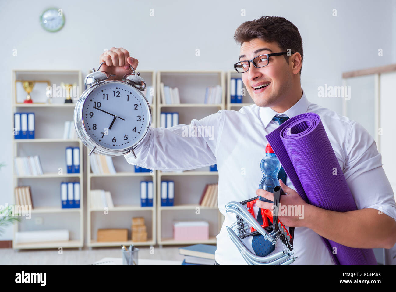 Businessman rushing to sports with clock Stock Photo - Alamy