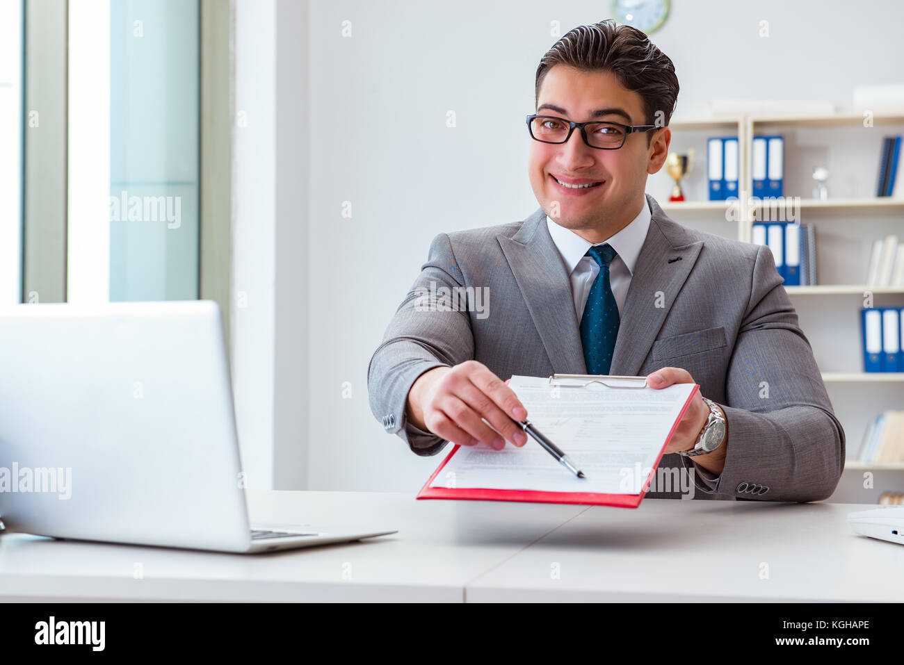 Businessman signing business documents in office Stock Photo - Alamy