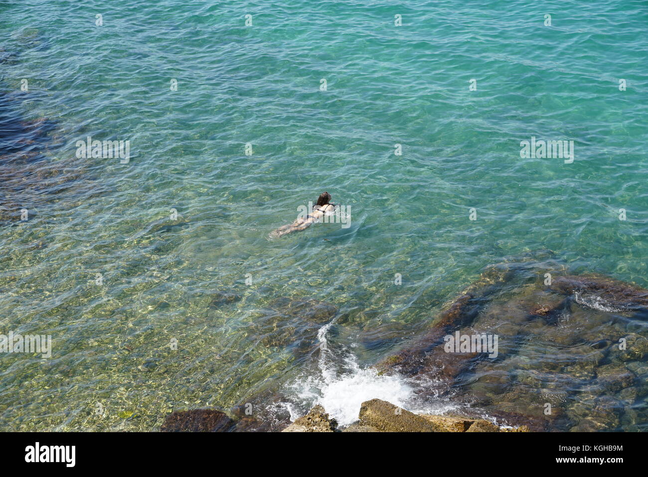 Corfu, Greece: Woman swimming in the sea at the beach of Kerkyra Old ...