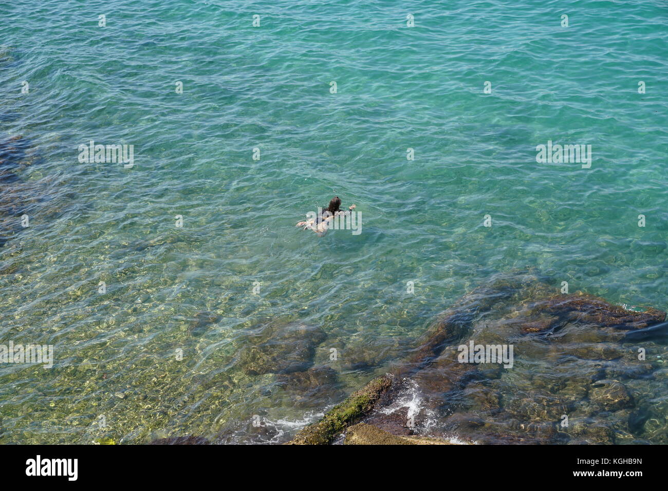 Corfu, Greece: Woman swimming in the sea at the beach of Kerkyra Old ...