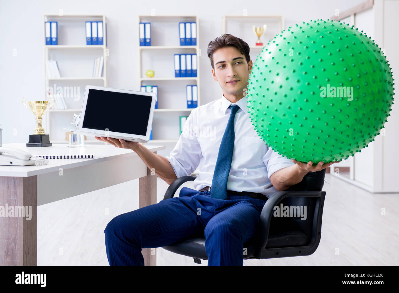 Young businessman doing sports stretching at workplace Stock Photo - Alamy