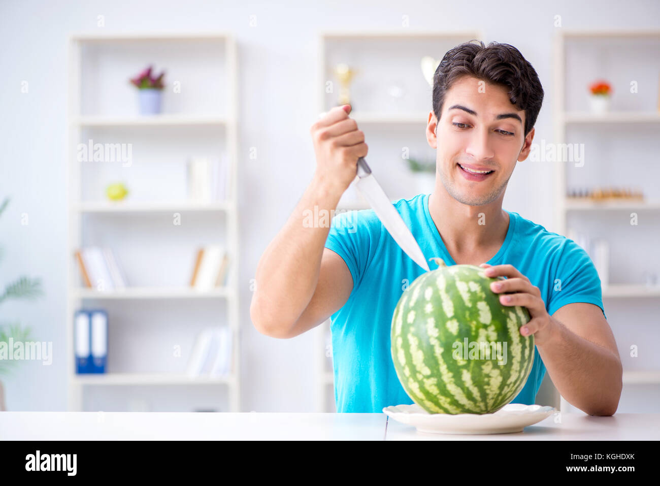 Man eating watermelon at home Stock Photo - Alamy