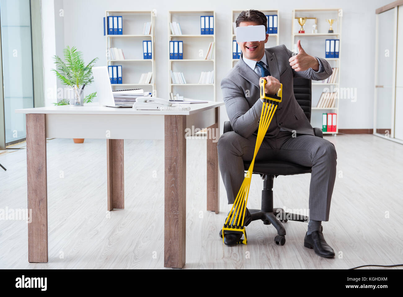 Businessman exercising with elastic expander wearing VR glasses Stock ...