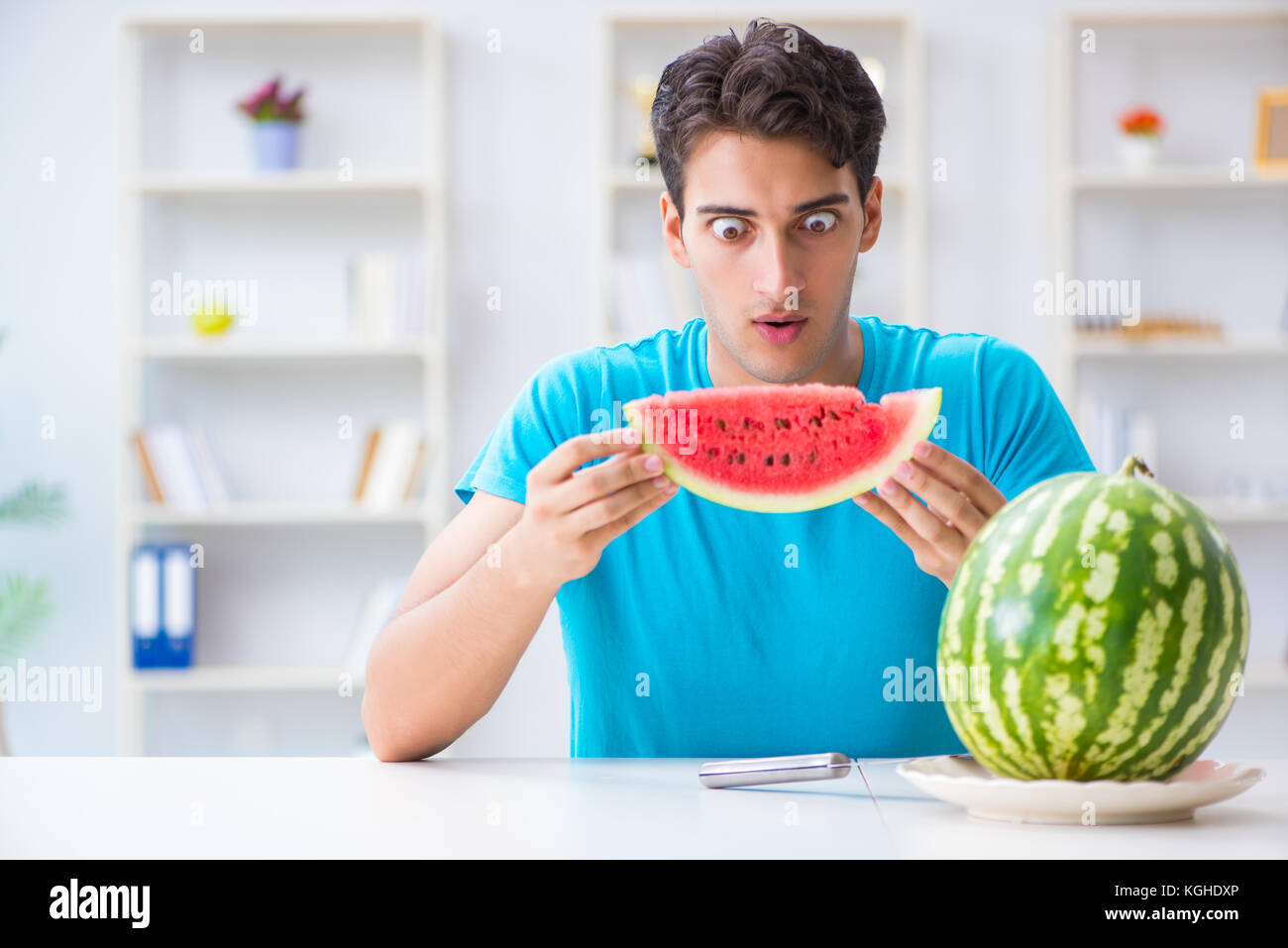 Man eating watermelon at home Stock Photo - Alamy