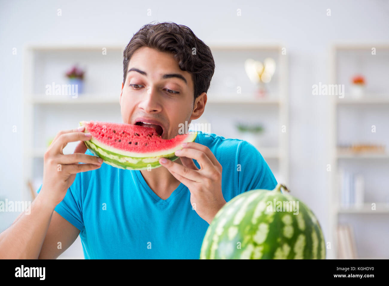 Man eating watermelon at home Stock Photo - Alamy