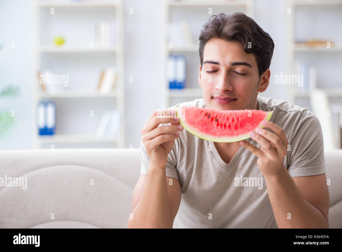Man eating watermelon at home Stock Photo - Alamy
