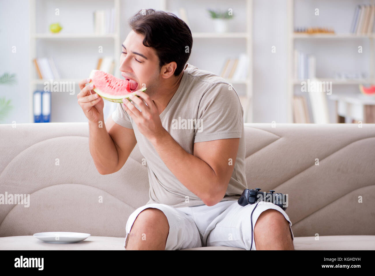 Man eating watermelon at home Stock Photo - Alamy