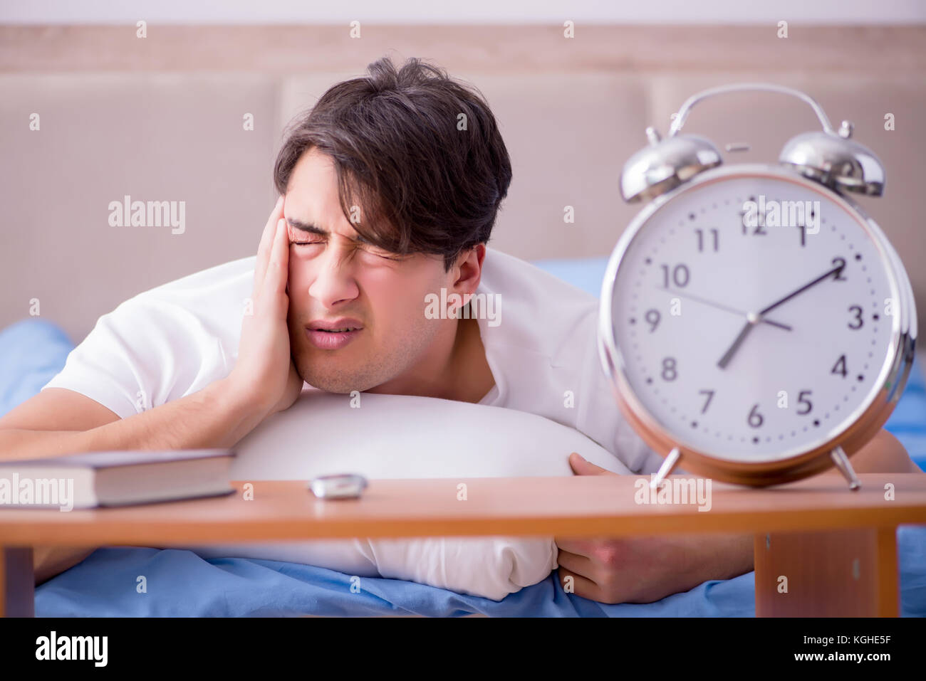 Man in bed frustrated suffering from insomnia with an alarm clock Stock ...