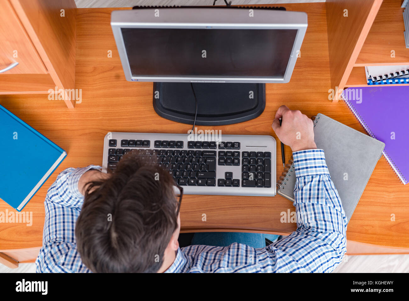 Young student at computer table Stock Photo - Alamy