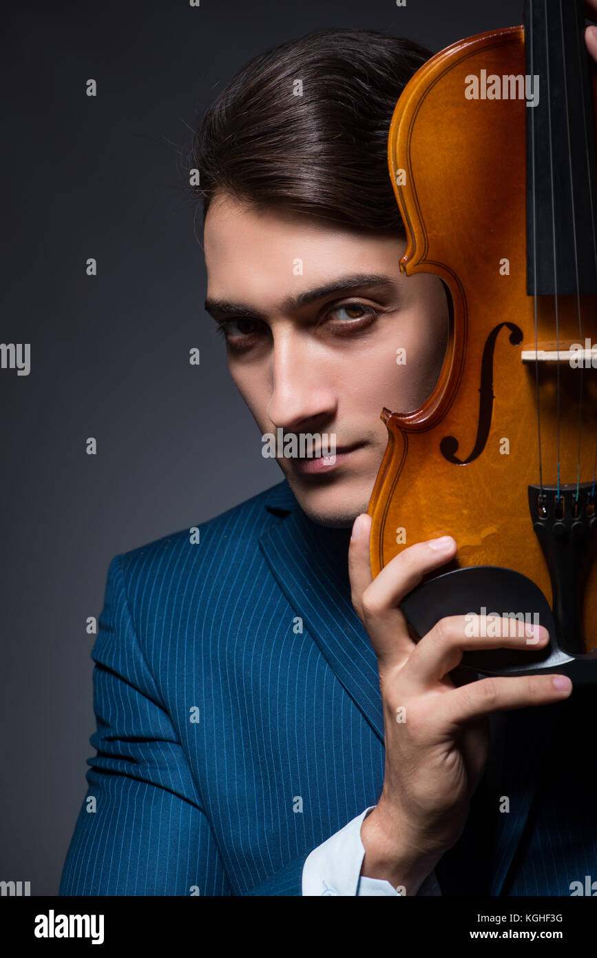 Young man playing violin in dark room Stock Photo - Alamy