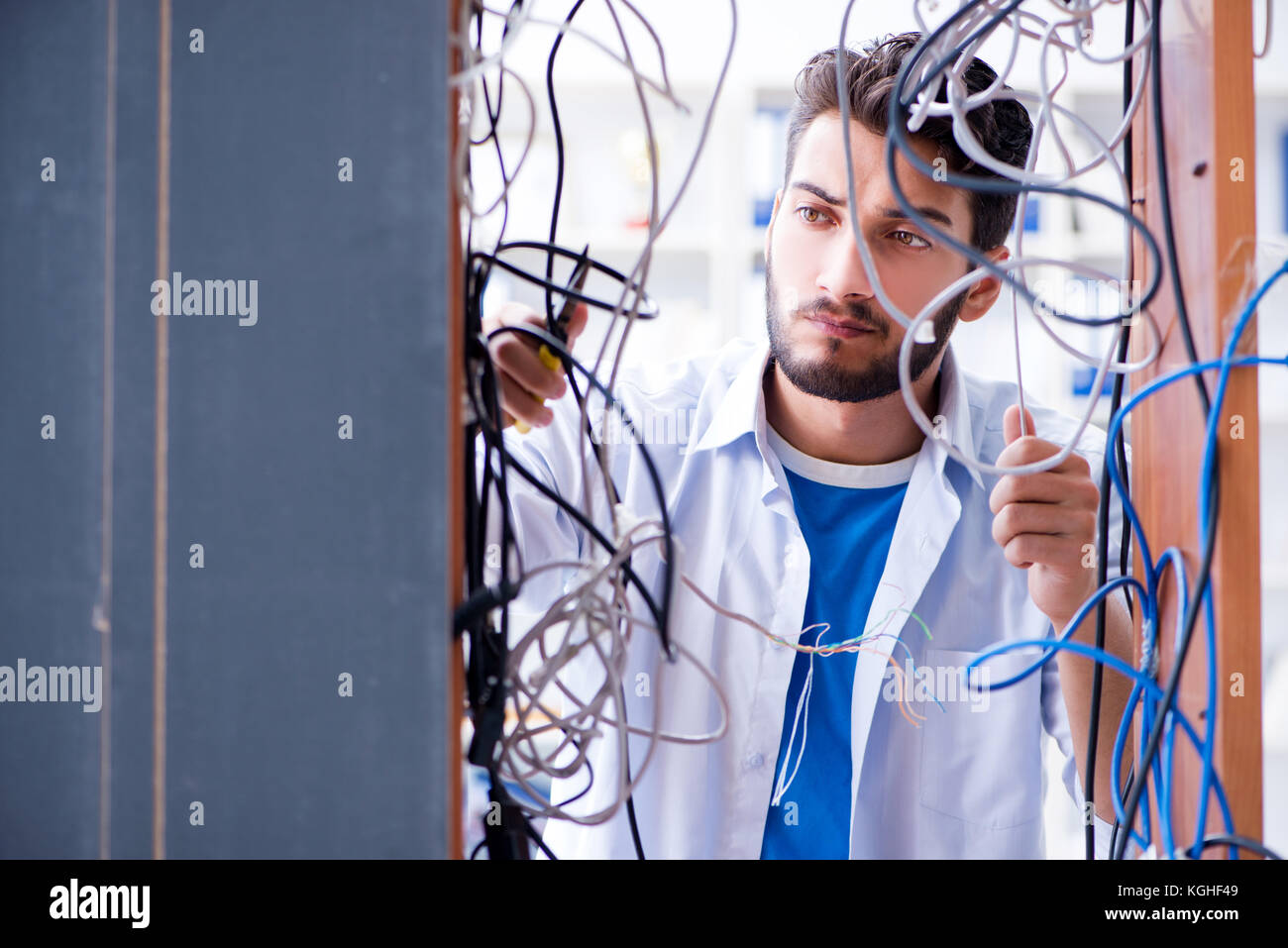 Electrician trying to untangle wires in repair concept Stock Photo - Alamy