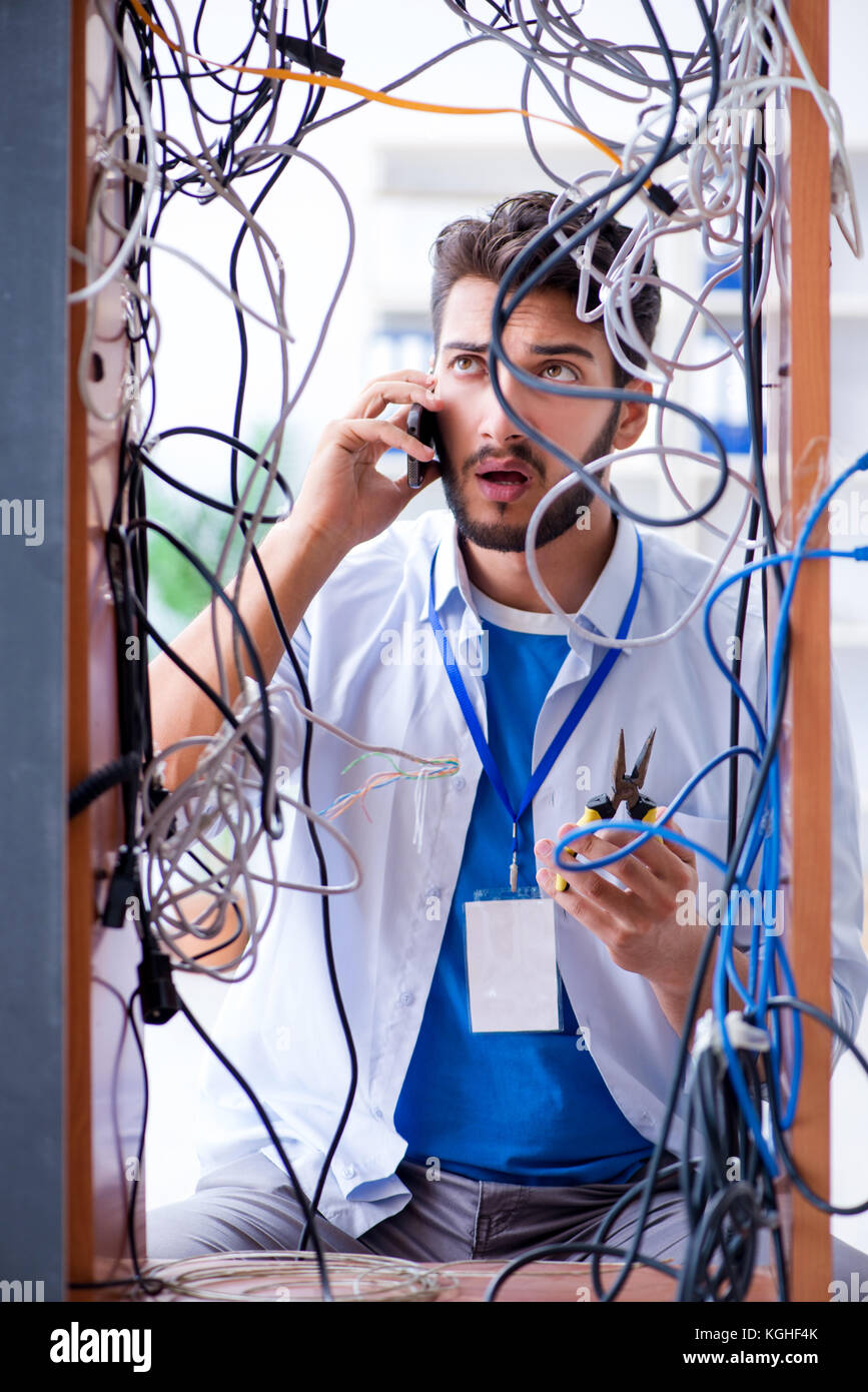 Electrician trying to untangle wires in repair concept Stock Photo - Alamy