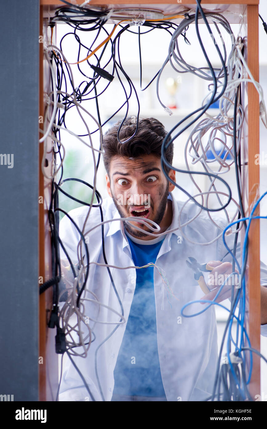 Electrician trying to untangle wires in repair concept Stock Photo - Alamy