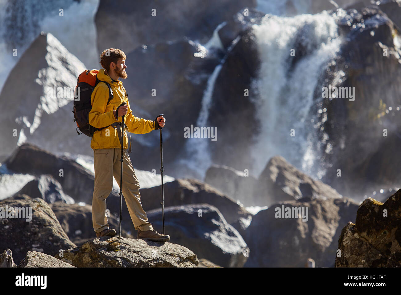 Hiker hiking with backpack looking at waterfall in park in beautiful ...