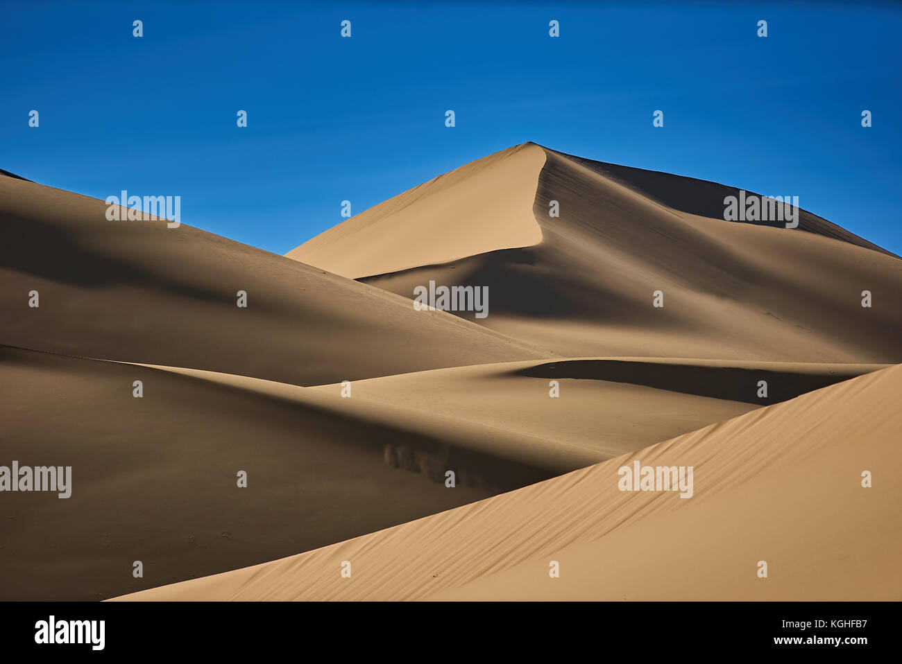 Smooth sand dunes in the desert, warm dry sand and blue sky with no ...