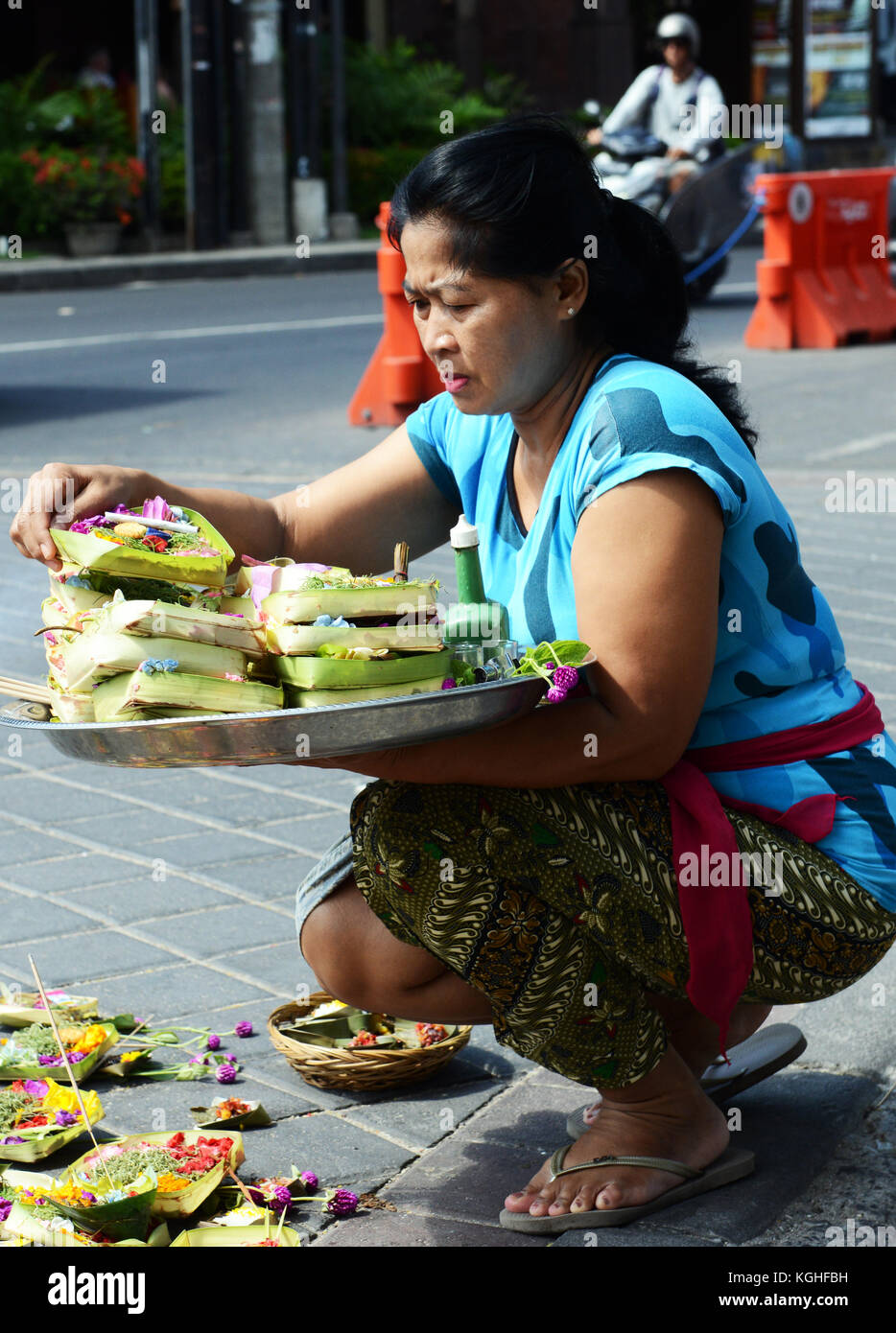A woman performing a morning offering ceremony. A traditional Balinese ...