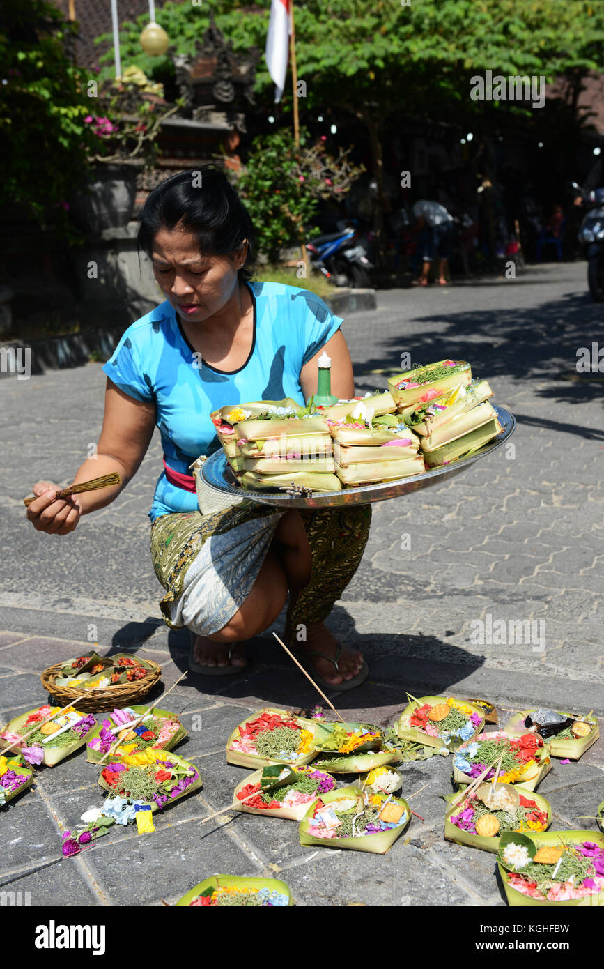 A woman performing a morning offering ceremony. A traditional Balinese ...