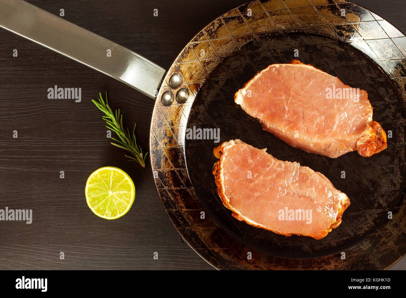 Pork chop on a steel kitchen pan. Fried steak. Kitchen utensils Stock ...