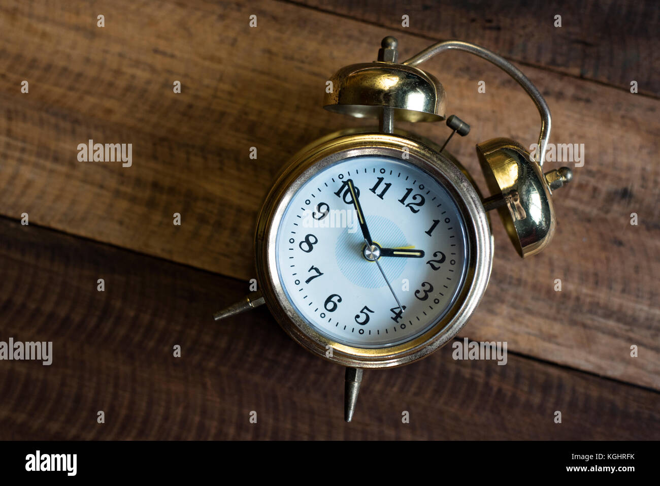 golden time clock - Golden bell clock on a wooden table background ...
