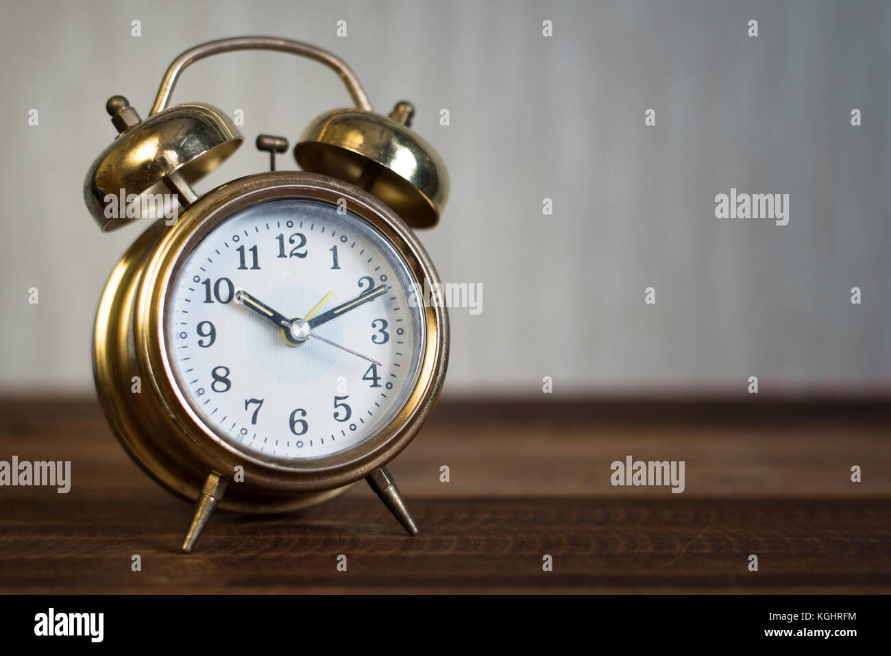 golden time clock - Golden bell clock on a wooden table background ...
