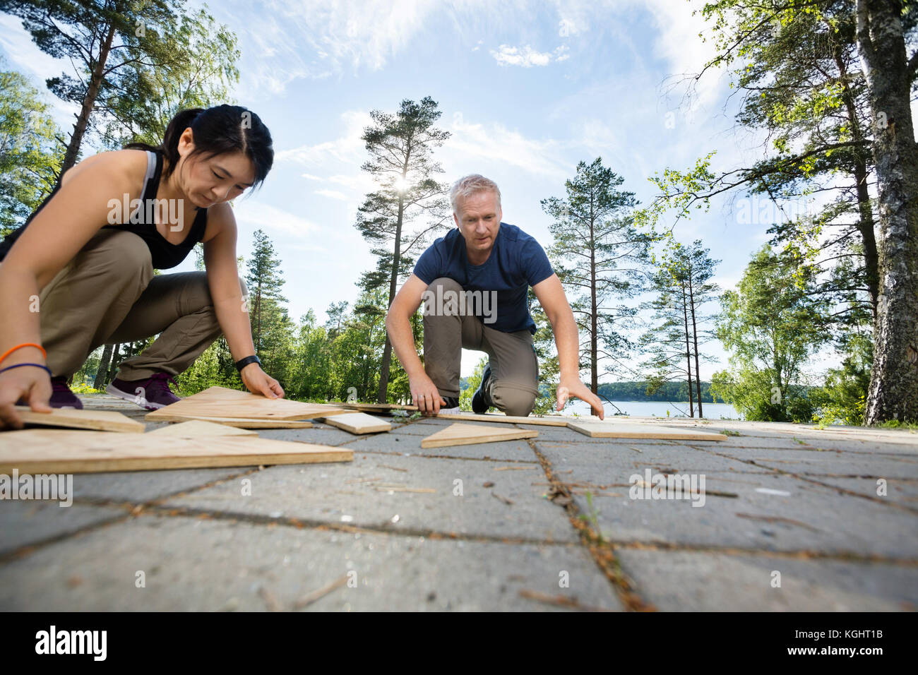 Friends Solving Puzzle With Wooden Planks On Patio Stock Photo - Alamy