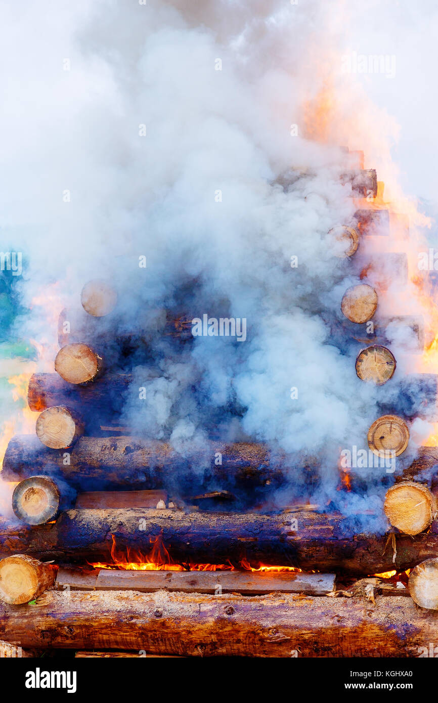 burning bonfire made of logs with flames and smoke Stock Photo - Alamy