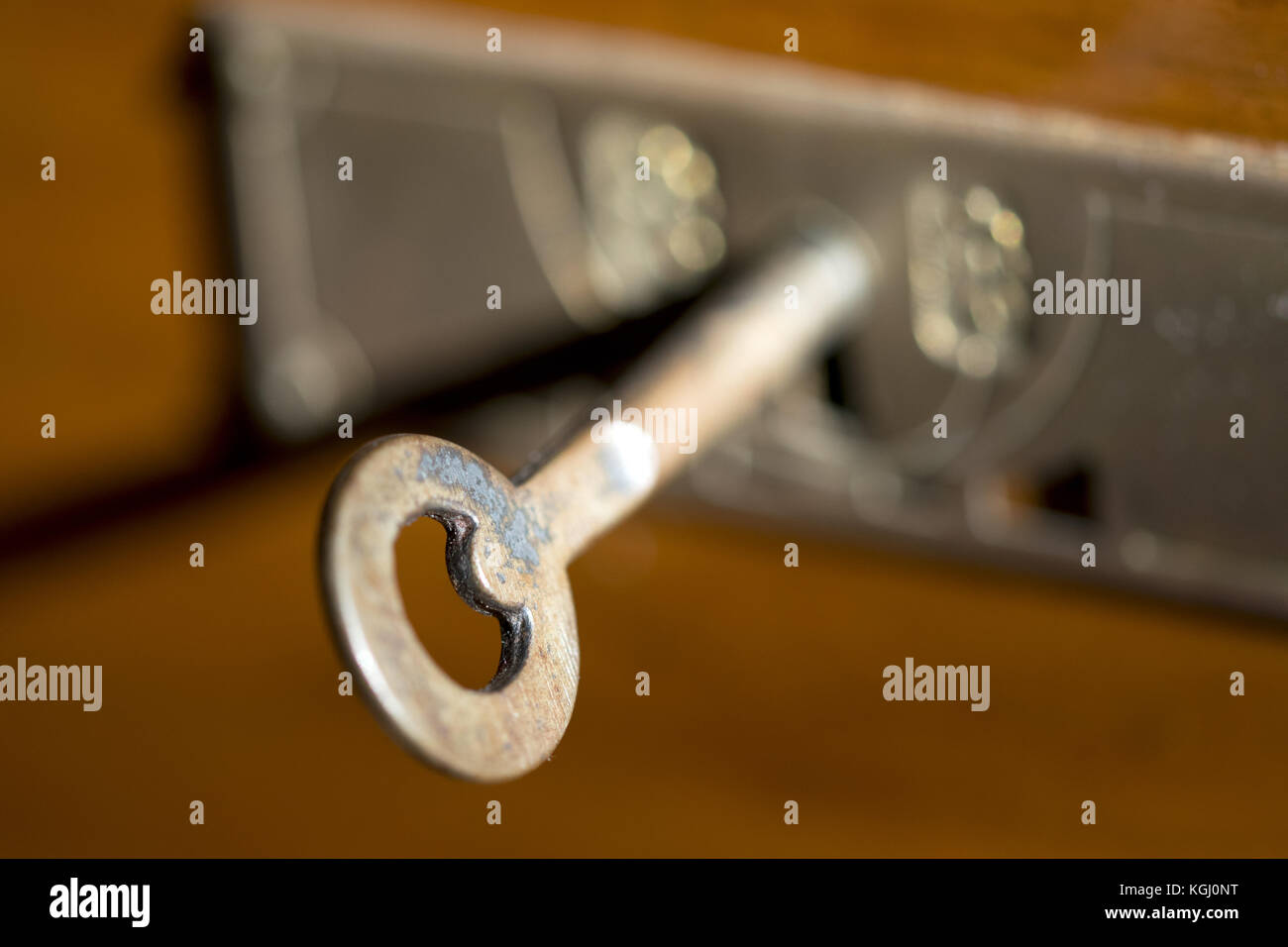 old brass key in a keyhole of a wooden drawer Stock Photo - Alamy