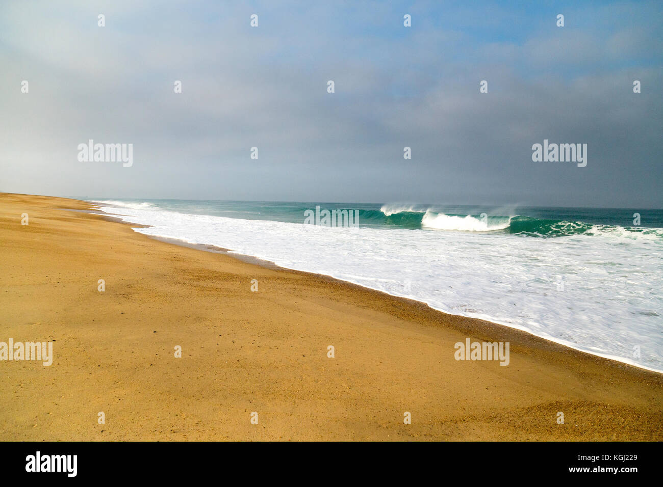 Waves breaking on sandy beach Stock Photo - Alamy