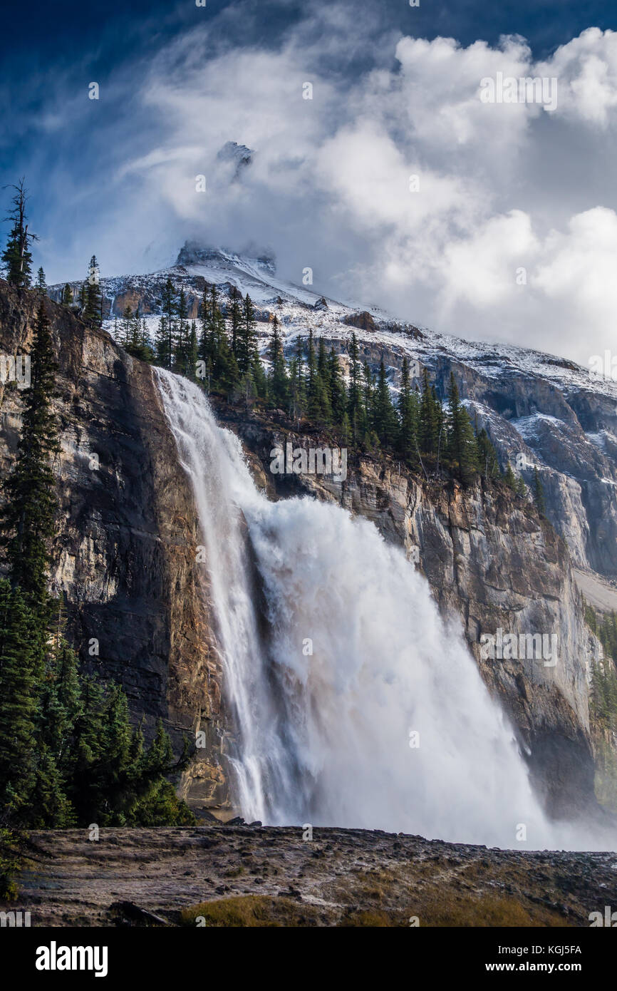 Raging Waterfall with Towering Mountain and Clouds Stock Photo - Alamy