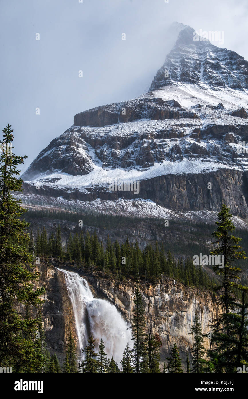 Raging Waterfall with Towering Mountain and Clouds Stock Photo - Alamy