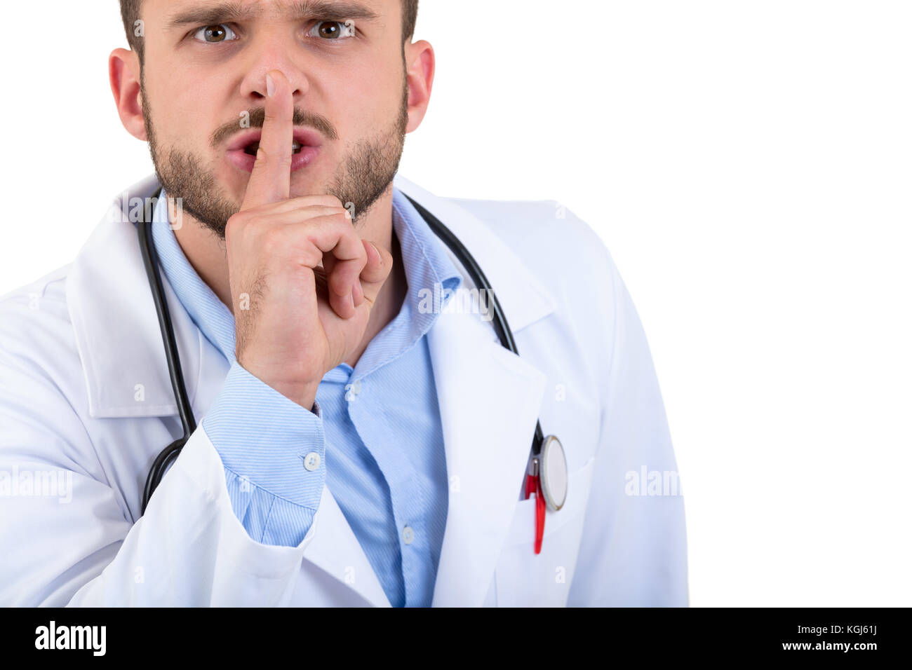 Young handsome doctor gesturing silence with his finger over his mouth ...