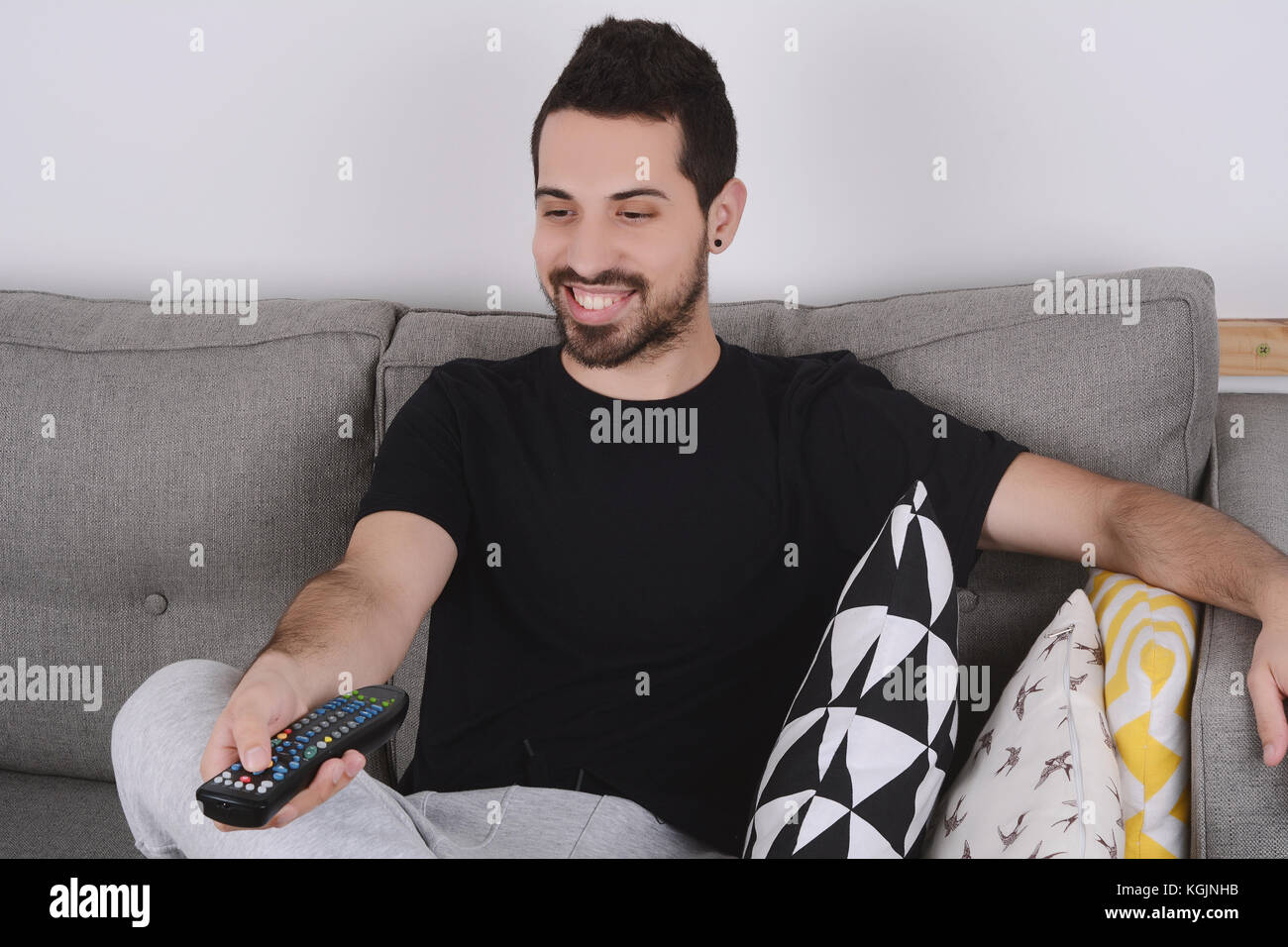 Attractive young man watching tv and relaxed on couch. Indoors Stock ...
