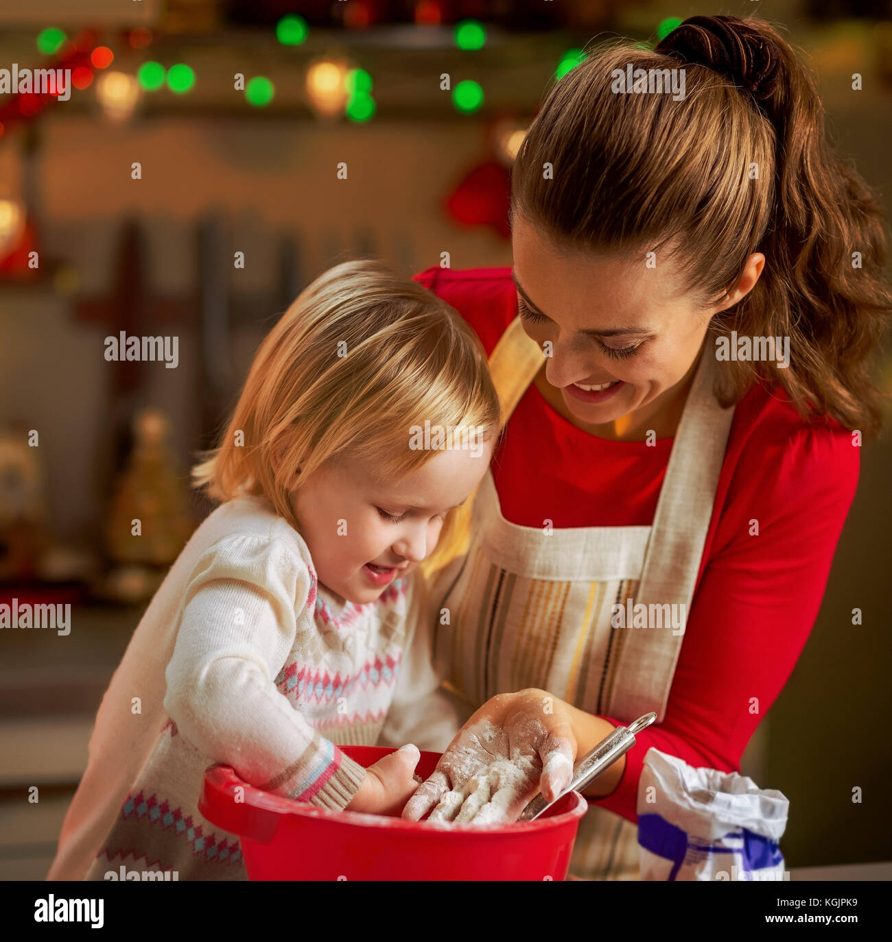 Mother and baby playing while making christmas cookies in kitchen Stock ...