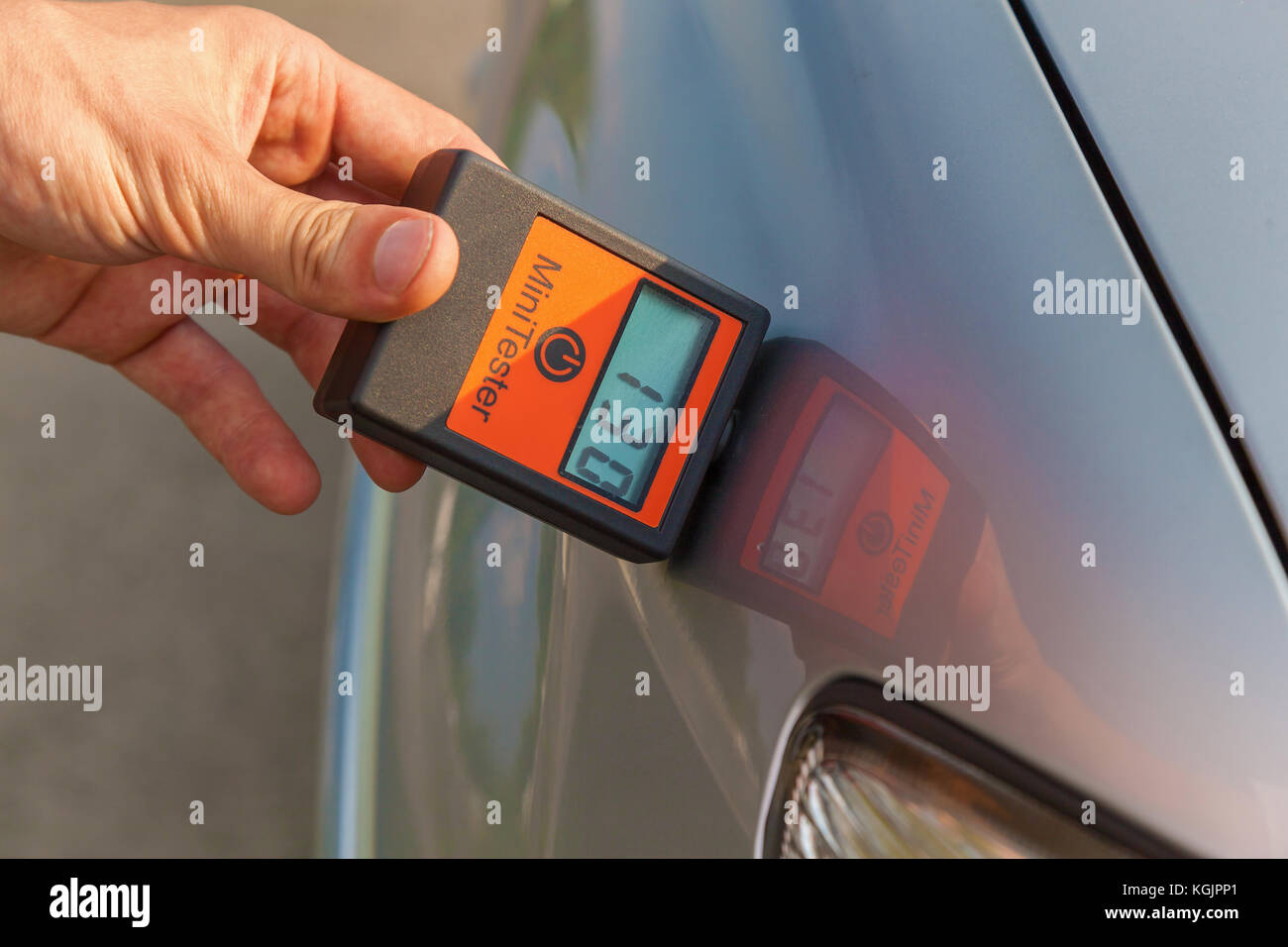 checking the body and doors of the car, the man measures the car's body ...