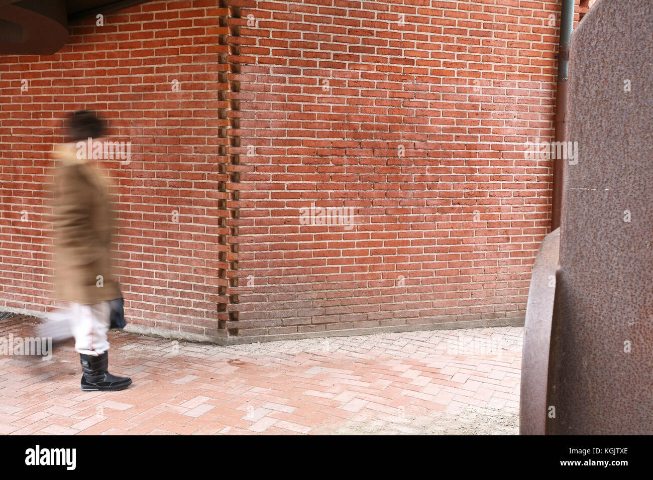 People passing by a brick wall Stock Photo - Alamy